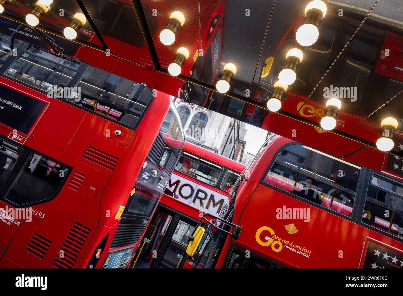 Red London double decker buses reflected in the mirror ceiling outside ...