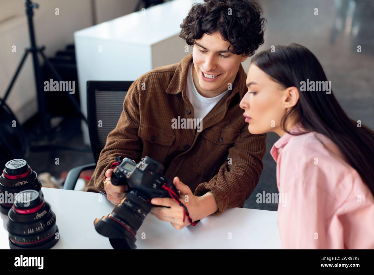 Photographer sharing camera screen with model after studio session ...