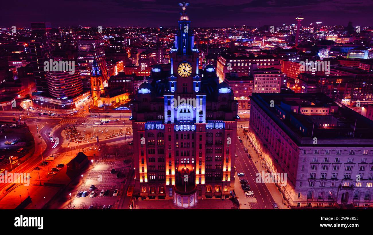 Aerial night view of an illuminated cityscape with a prominent clock ...