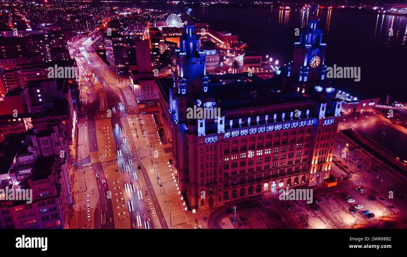 Aerial night view of an illuminated cityscape with a prominent clock ...