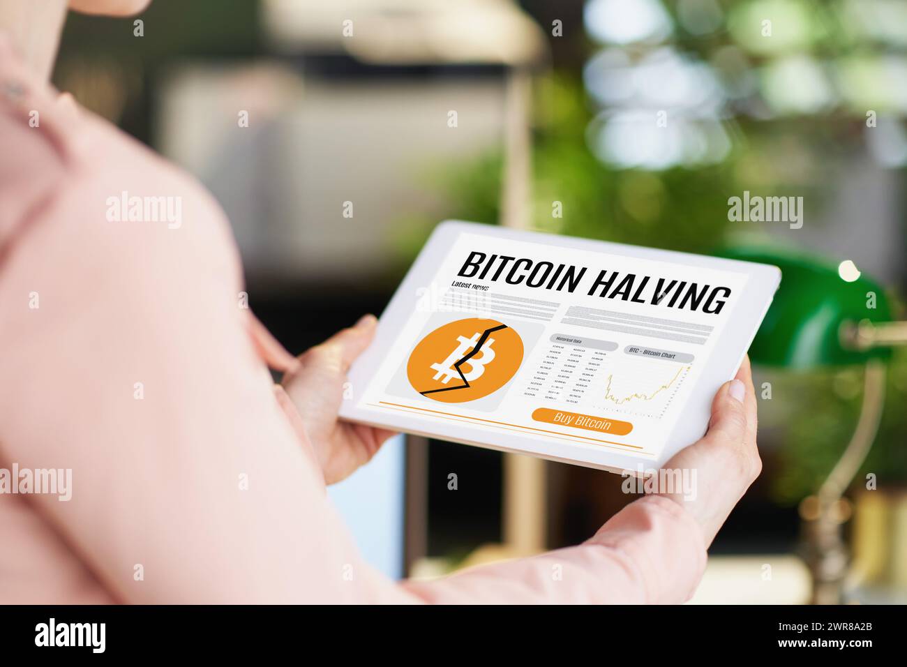 Closeup on modern business woman with tablet PC bitcoin halving screen in modern office Stock ...