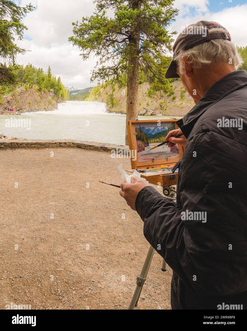 An artist painting nature's portrait down by the Bow Falls in Banff ...