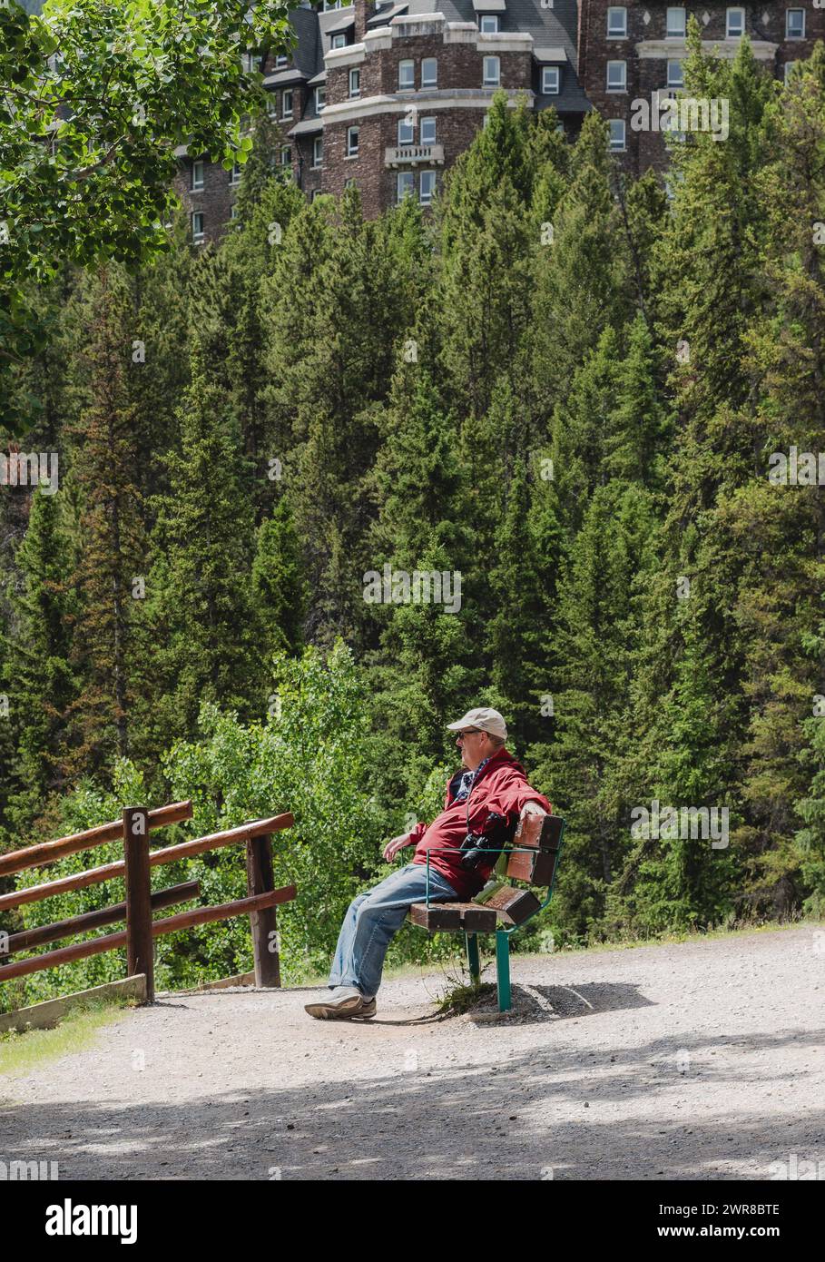 An old gentleman tourist taken a break on a park bench overlooking the ...