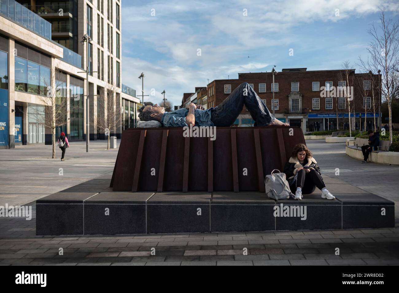 'Lying man' sculpture in Woking town centre, in Surrey, England, which ...