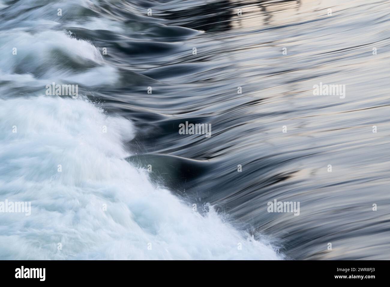 Rapid water flow over barrier with silky surface, river overflow over ...