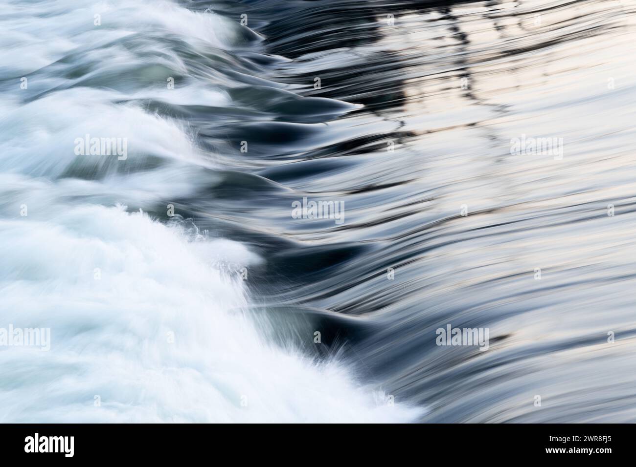 Rapid water flow over barrier with silky surface, river overflow over ...