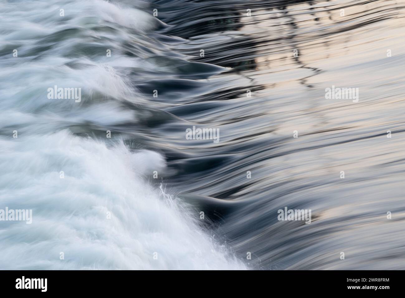 Rapid water flow over barrier with silky surface, river overflow over ...