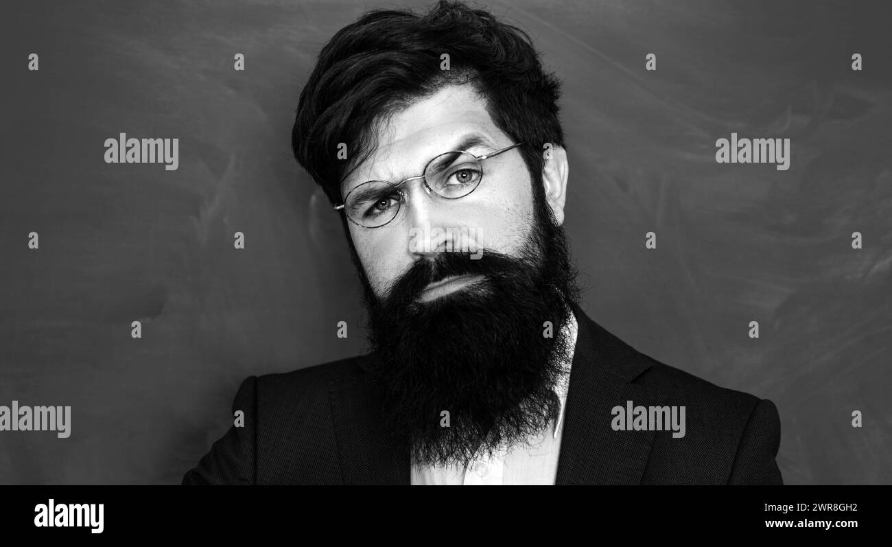 Portrait of bearded professor at school lesson at desks in classroom ...