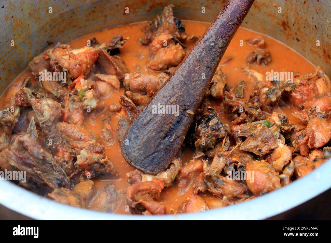 A pot of chicken stew is seen on an open fire. The meal was ready to be ...