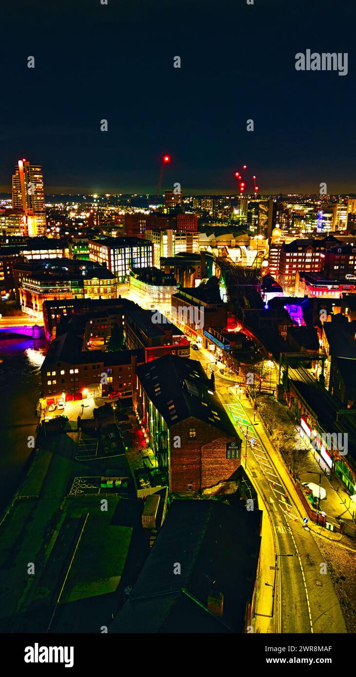 Vertical night cityscape with illuminated buildings and streets ...