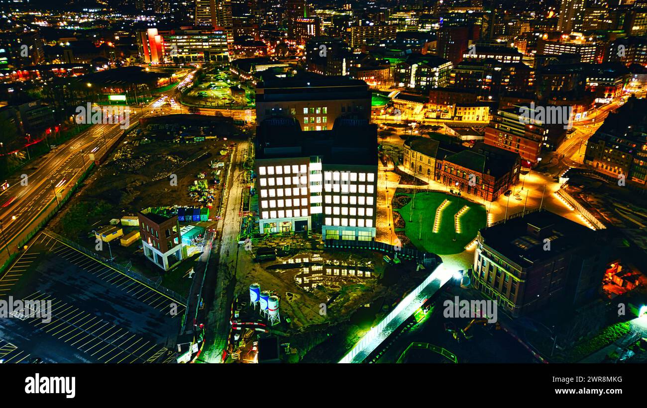 Aerial night view of an illuminated urban office building amidst city ...