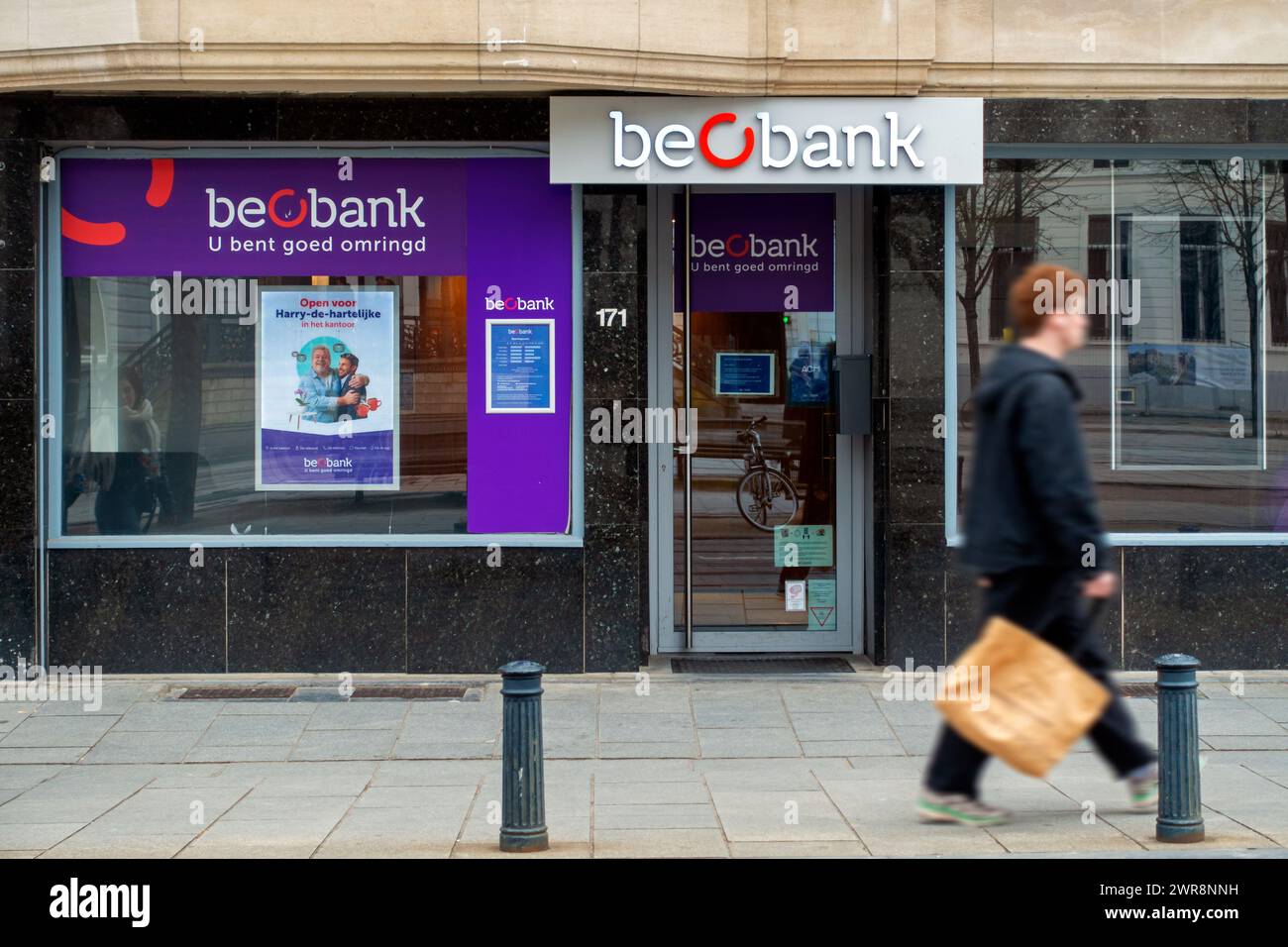 Shopper walking past Beobank bank office in the city centre of Ghent ...