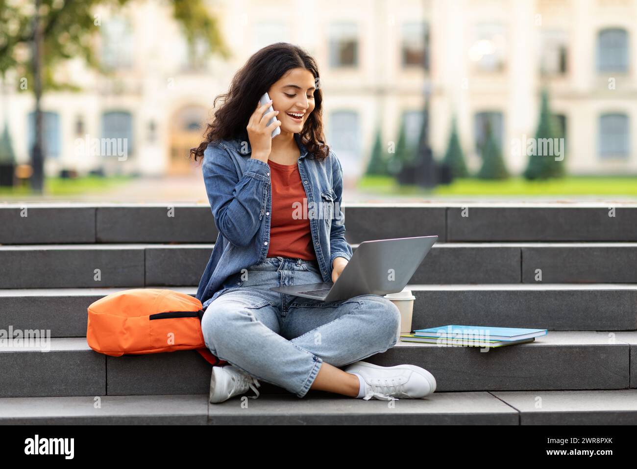 Young eastern woman student doing homework, calling her classmate Stock ...