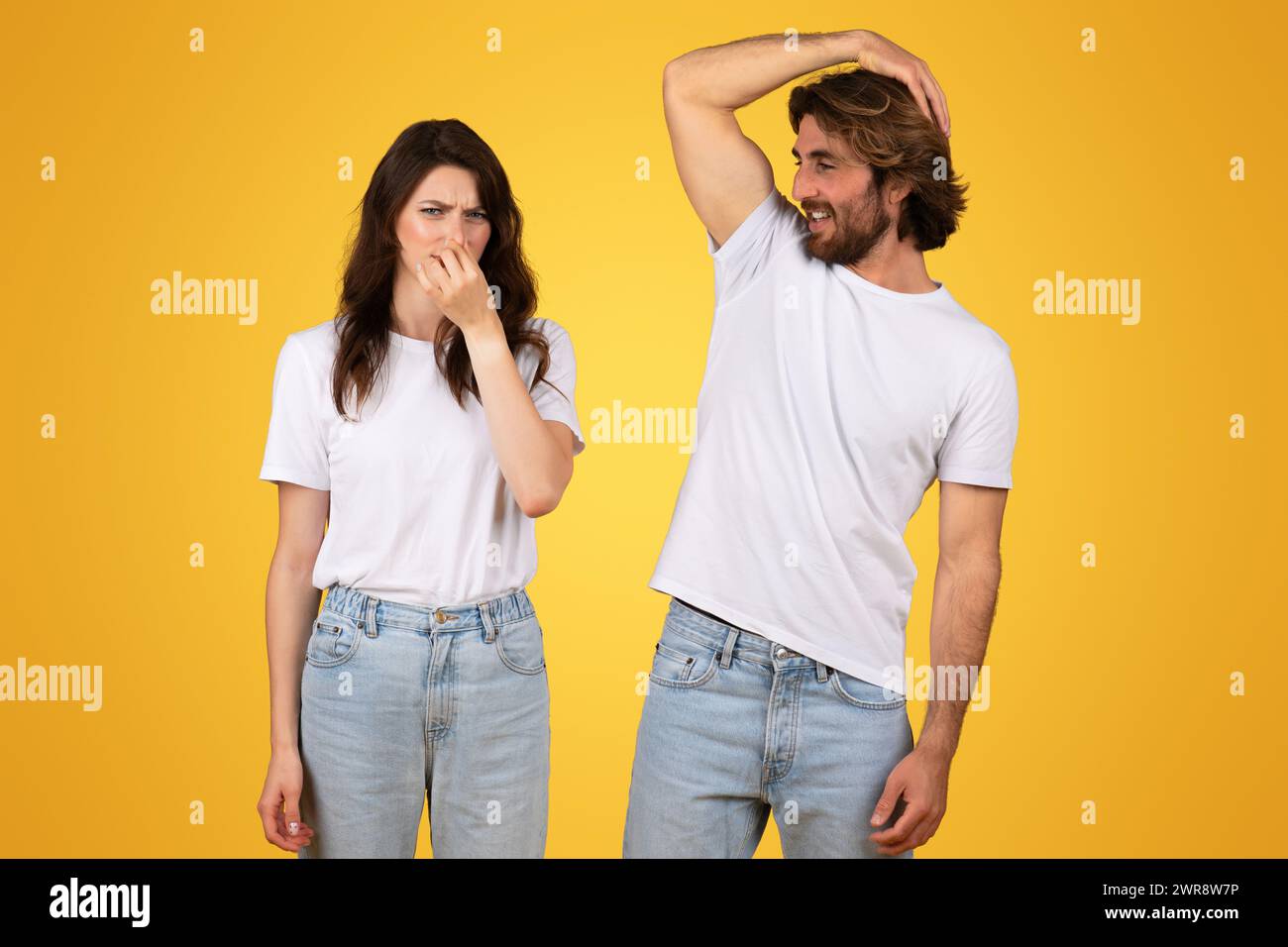A woman pinches her nose with a disgusted expression while a man ...