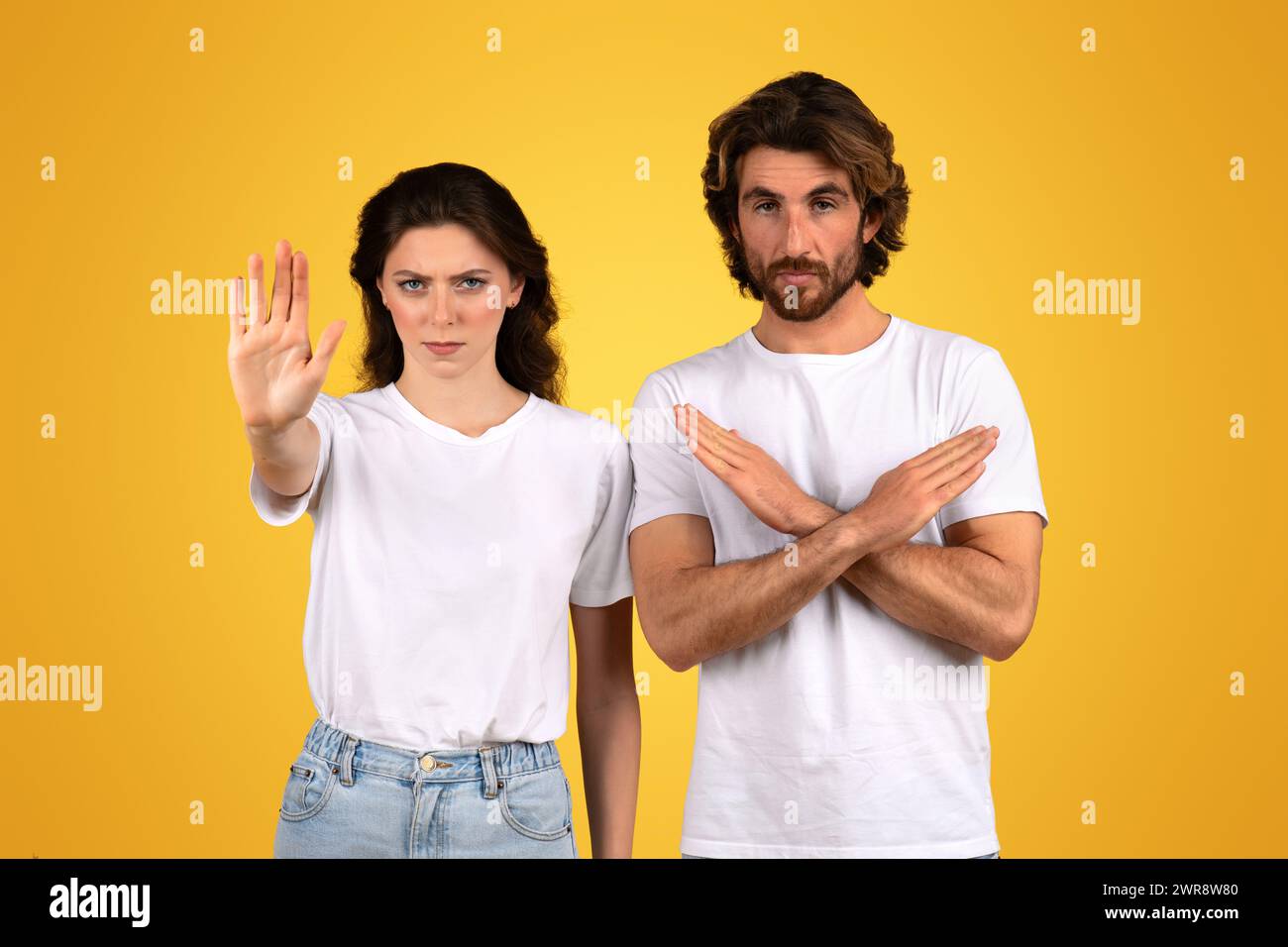 Determined woman with an outstretched hand signaling stop and a serious ...