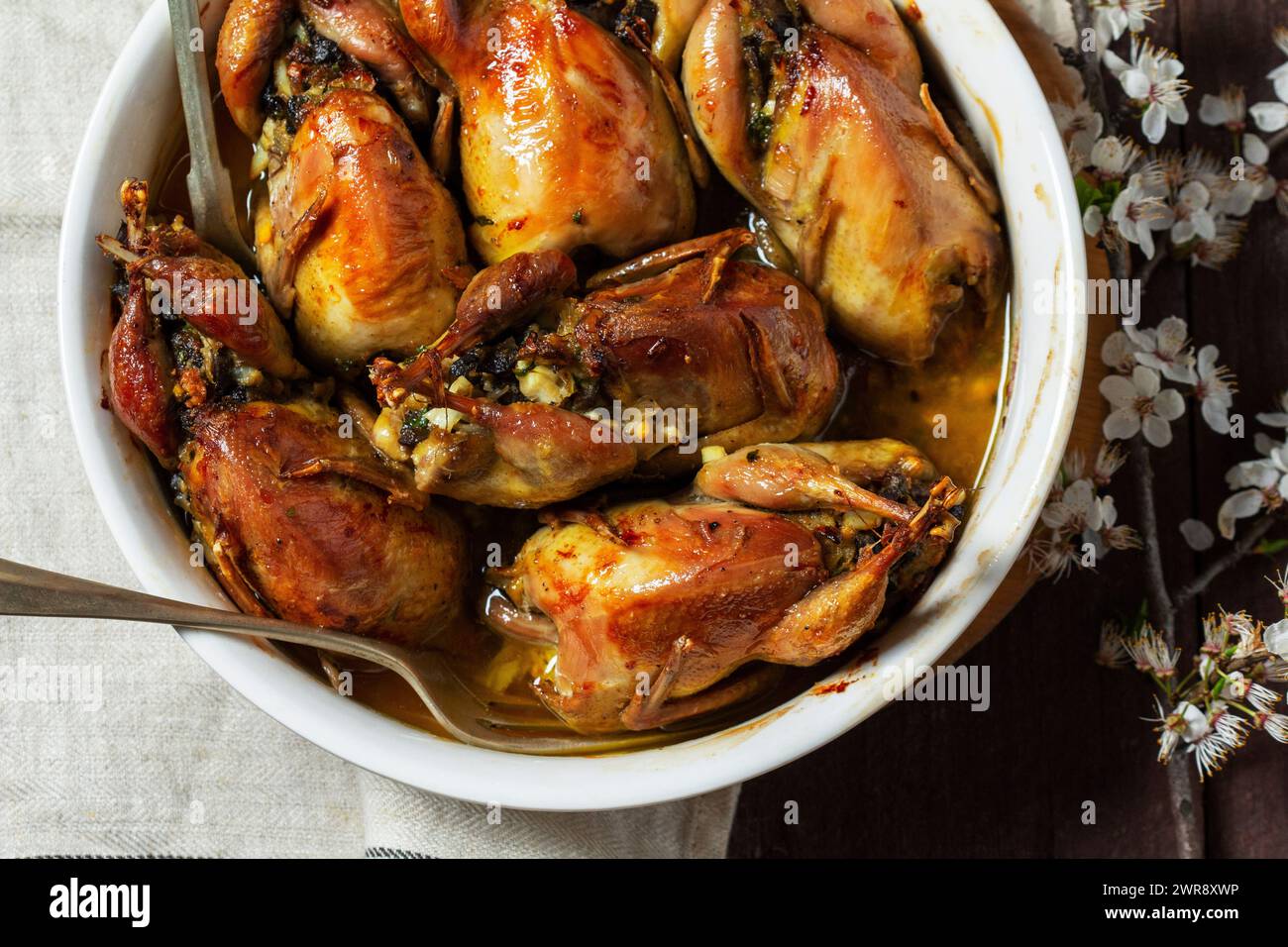 Baked quail stuffed with mushrooms, eggs and bread in a ceramic form on ...