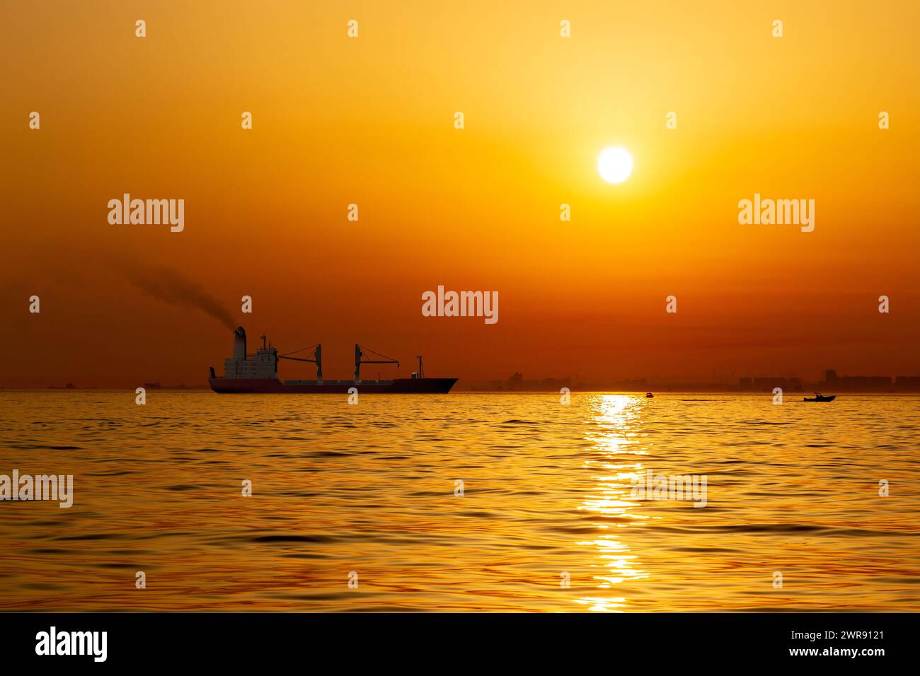 A silhouette of a cargo ship at sunset Stock Photo - Alamy
