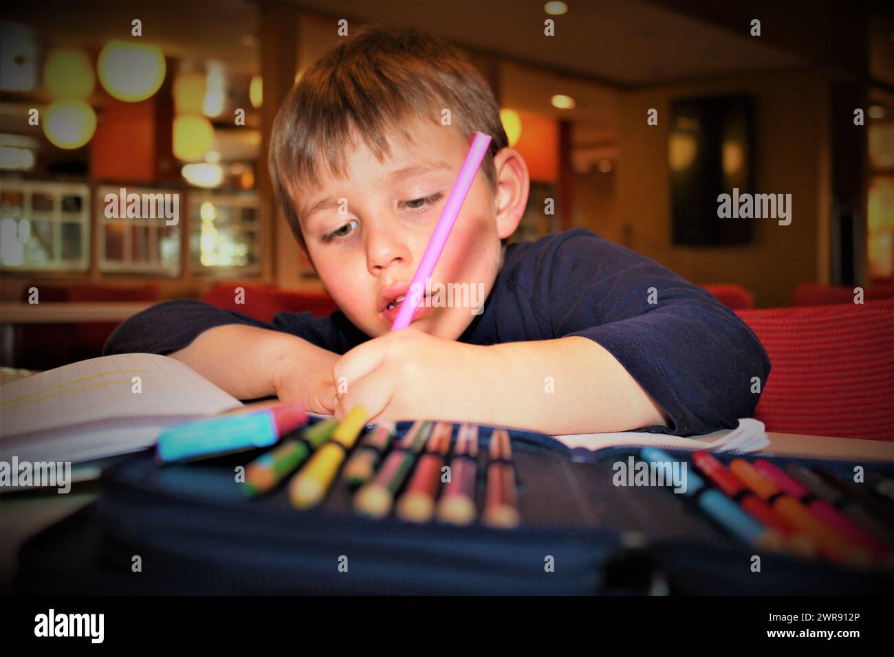 left-handed boy draws with colored pencils Stock Photo - Alamy