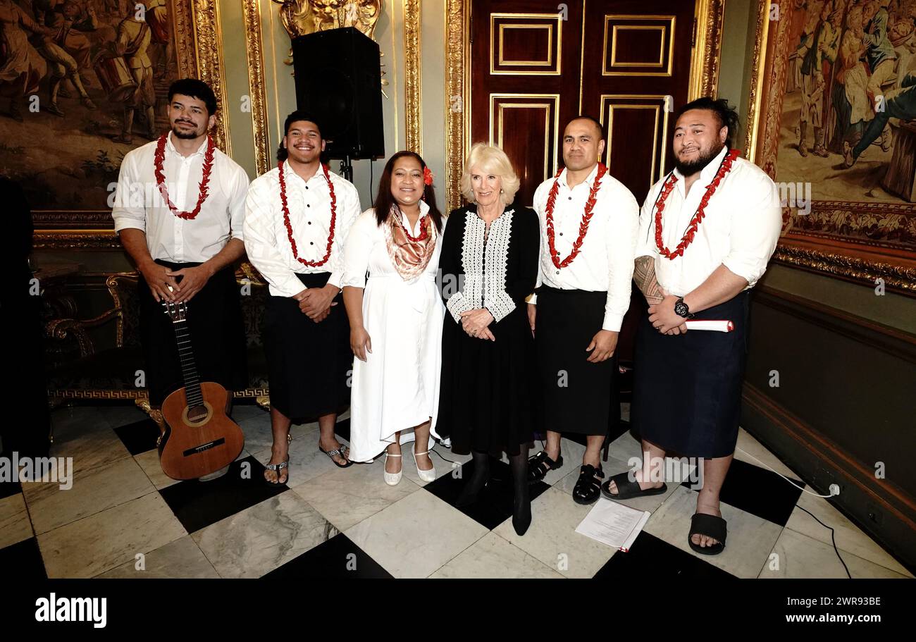 Queen Camilla poses for a photo with members of a Samoan band during ...