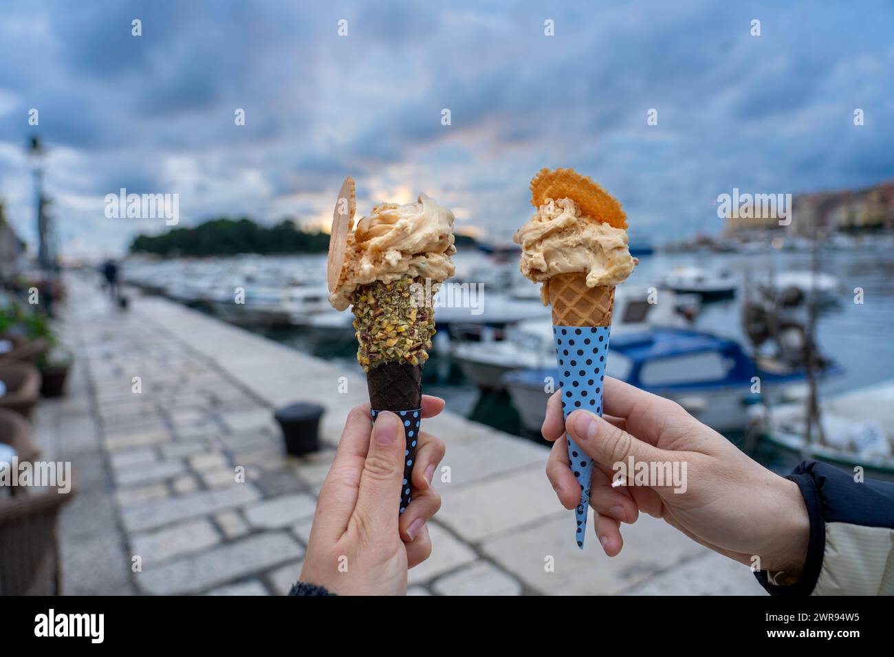 couple eating ice cream in Rovinj harbor with sunlight Stock Photo - Alamy