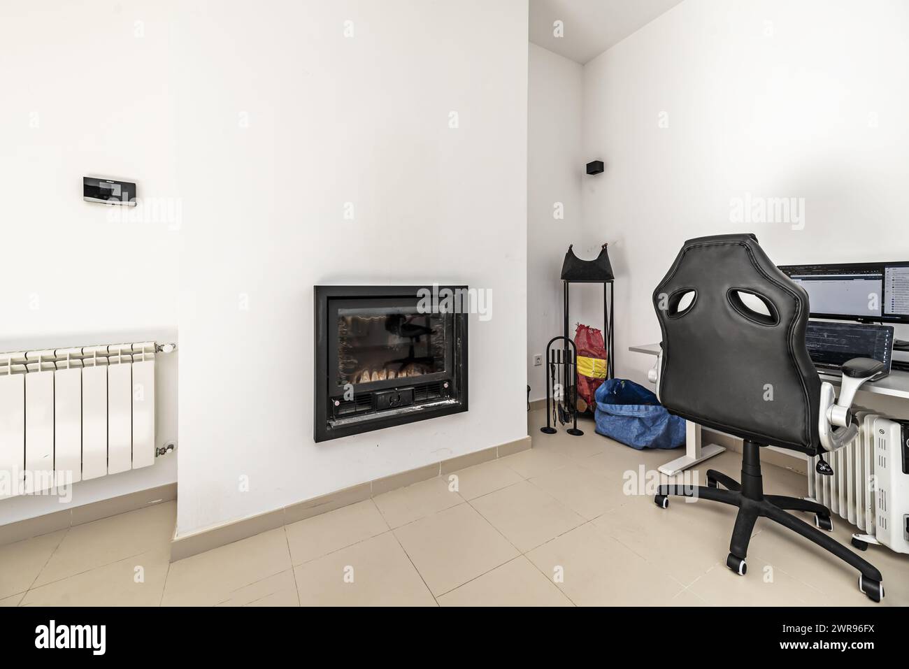 Corner of a living room with a wood-burning fireplace and a desk table ...