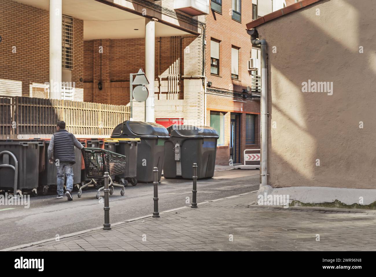 Person with few resources patrolling the garbage containers in search ...
