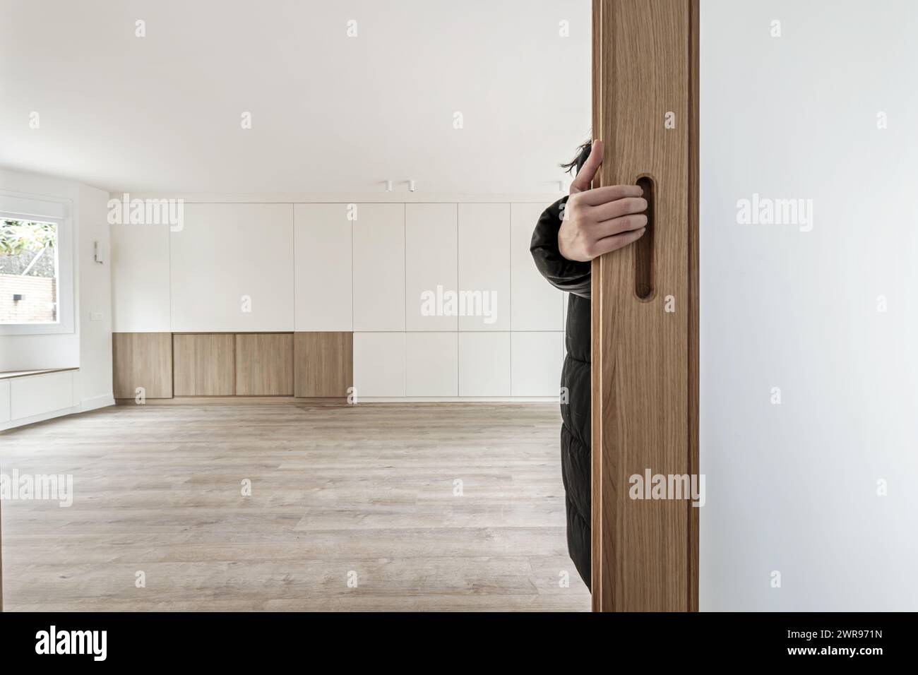 A young woman's hand pulling the frame of a door to open it Stock Photo ...