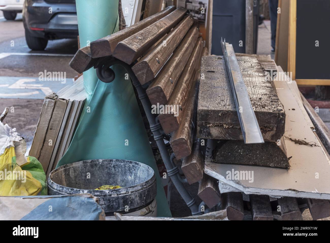 A stack of construction materials on a metal bench and wooden slats ...