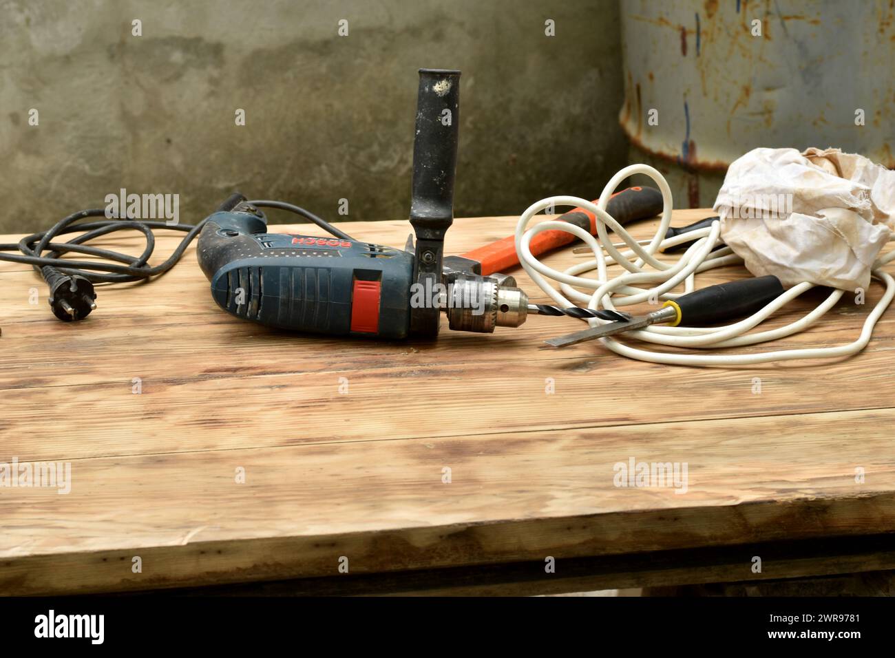 On the table at the carpenter lies a tool, a drill, a wire, a hammer ...