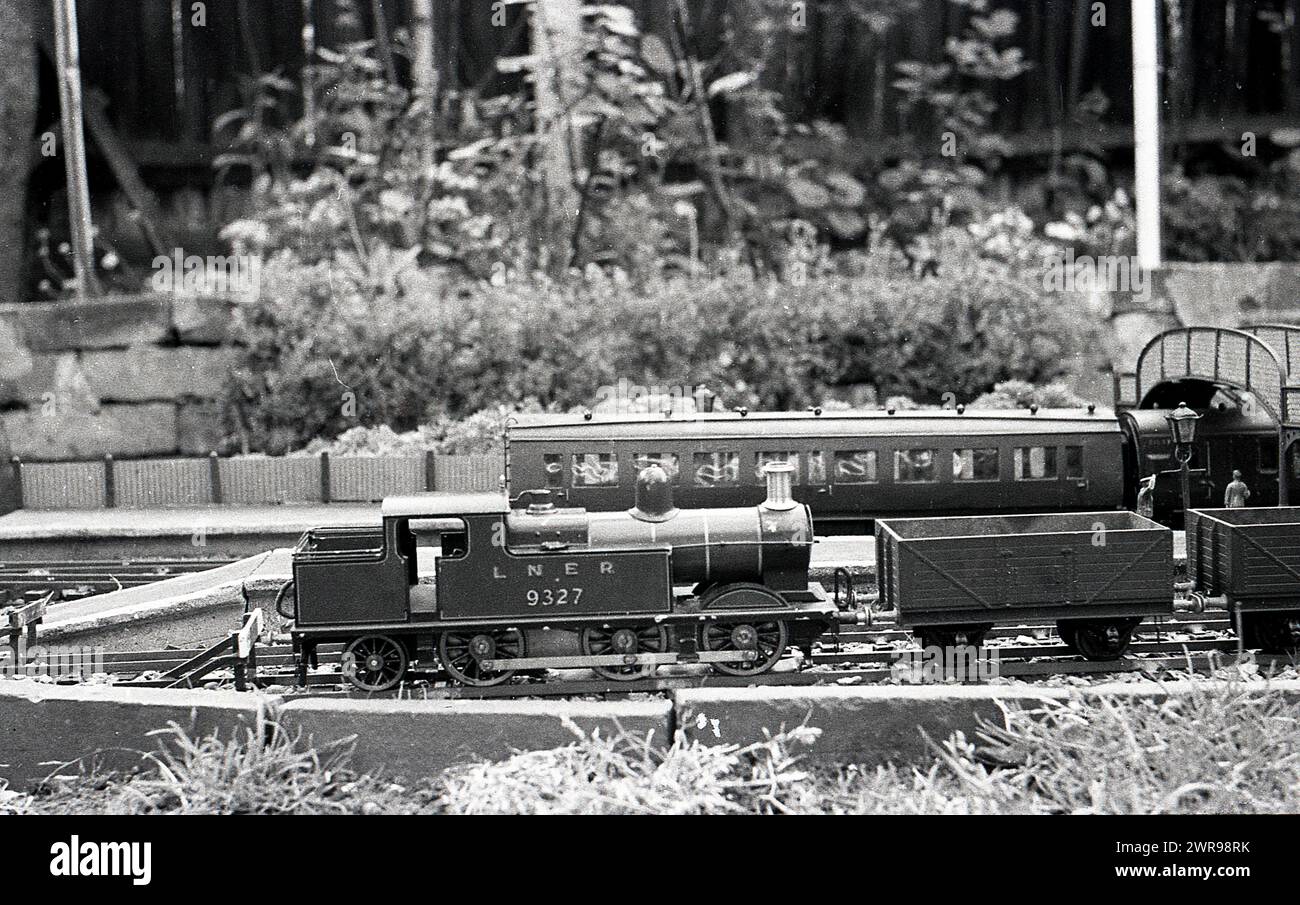 1970s, model railway, back garden showing a model train L.N. E. R 9327 ...
