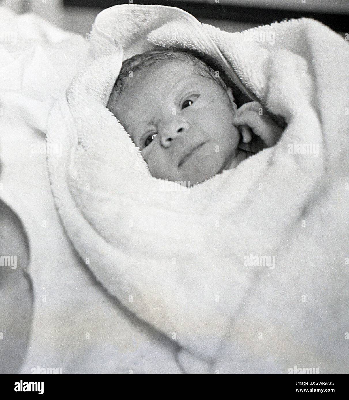 1970s, historical, new life, newly born baby wrapped in a cotton towel ...