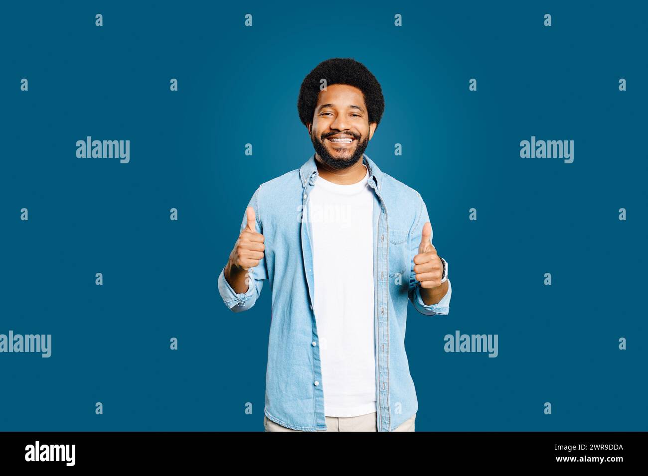 With a bright smile, the African-American man gives two thumbs up ...