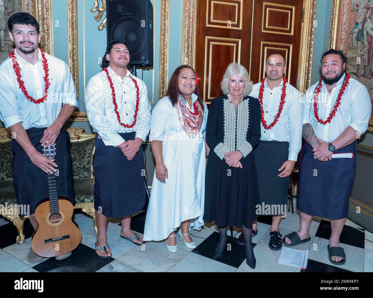 Queen Camilla poses for a photo with members of a Samoan band during ...