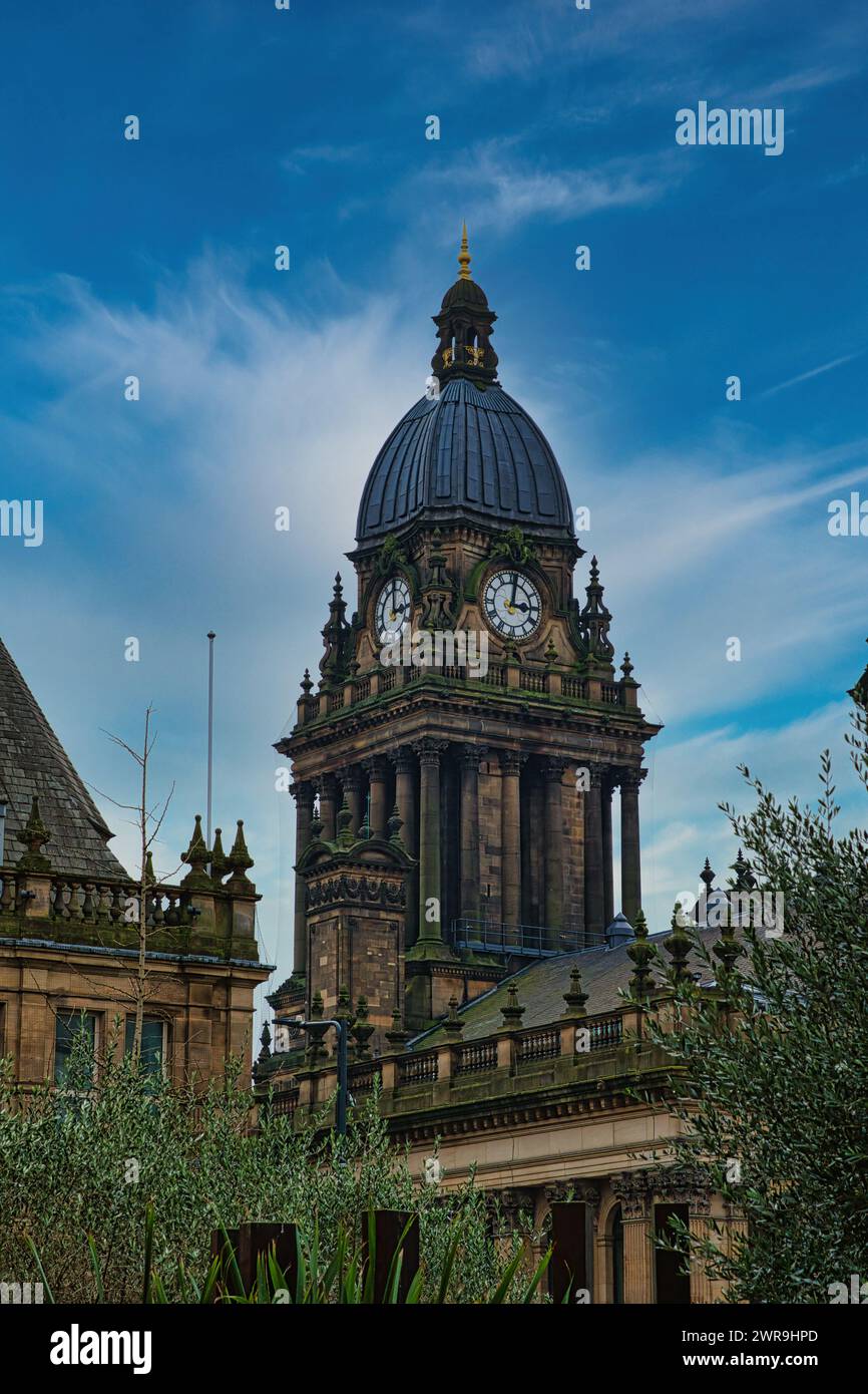 Victorian architecture of an ornate clock tower against a blue sky with ...