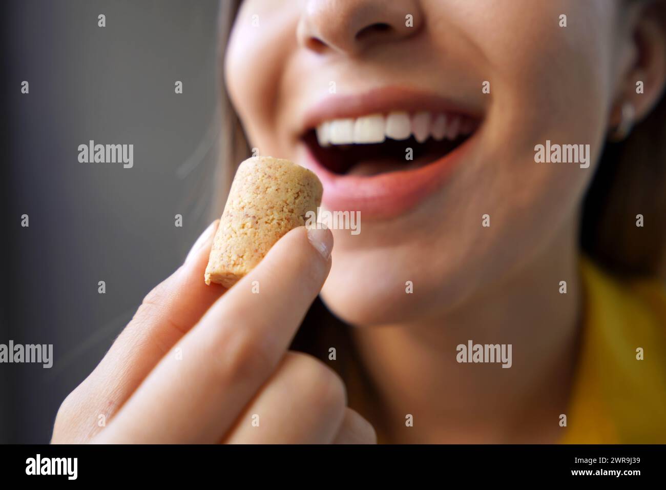 Peanut candy (paçoca or pacoca). Extreme close-up of beautiful girl ...