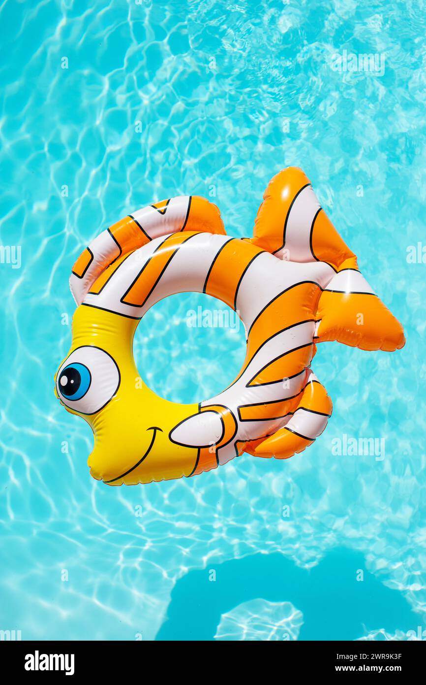 Inflatable fish ring in swimming pool Stock Photo - Alamy