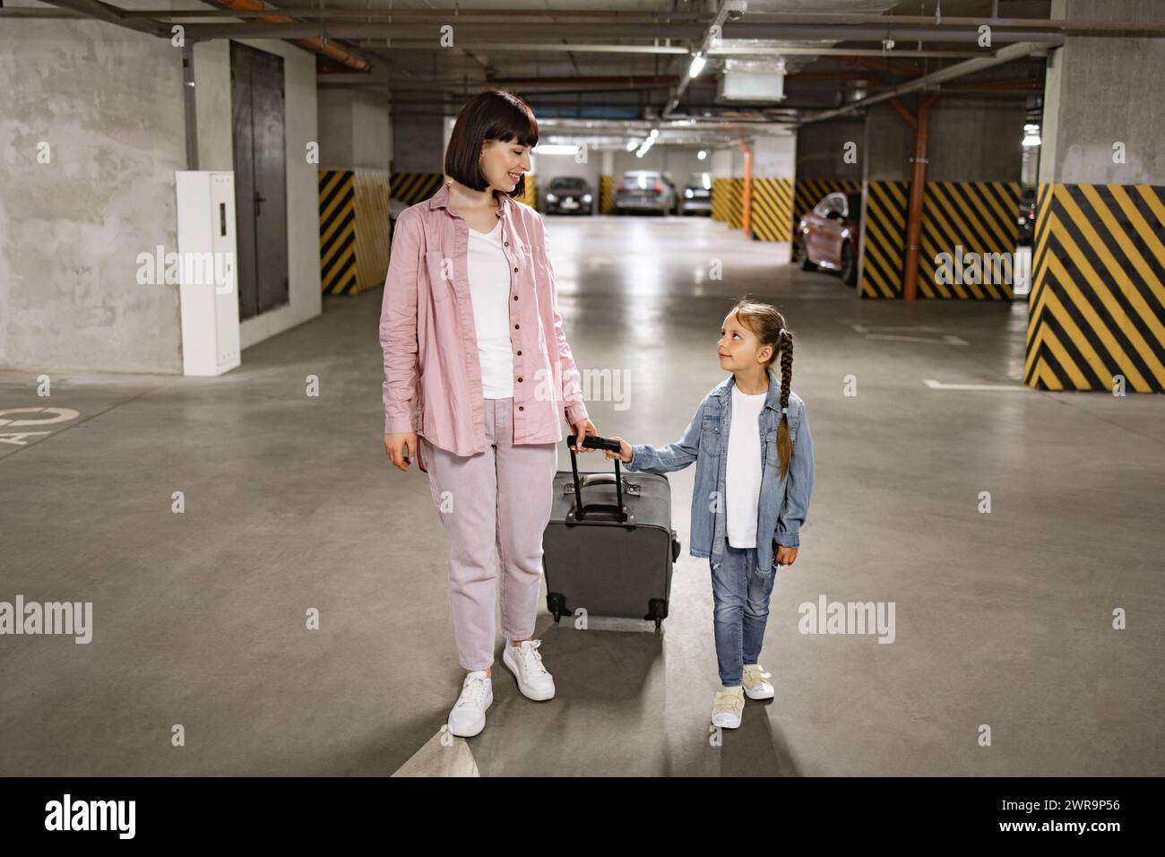 Caucasian mother and little daughter walking through underground ...