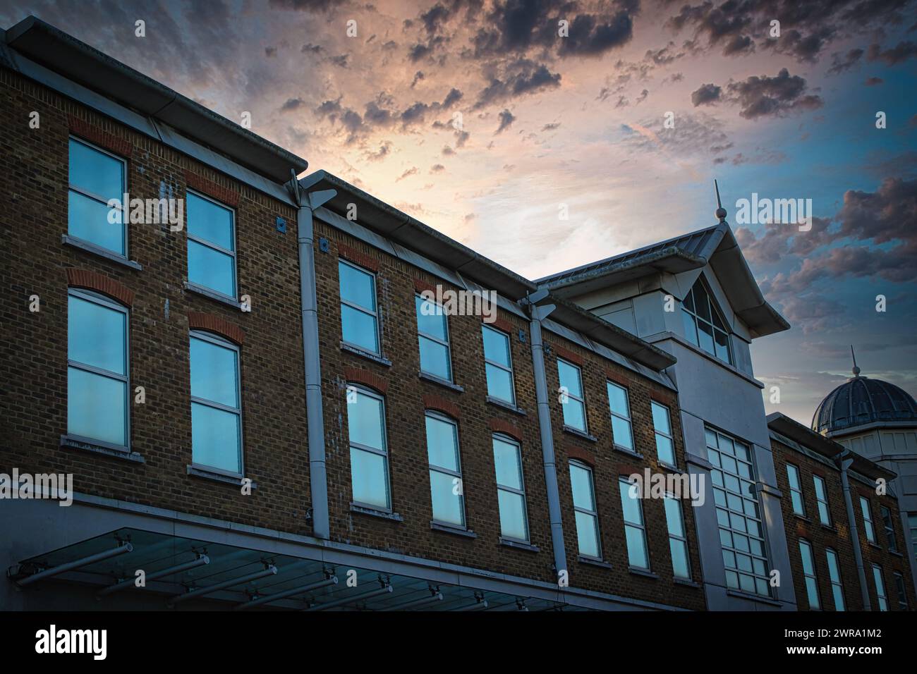 Classic building facade against a dramatic sunset sky with clouds Stock ...