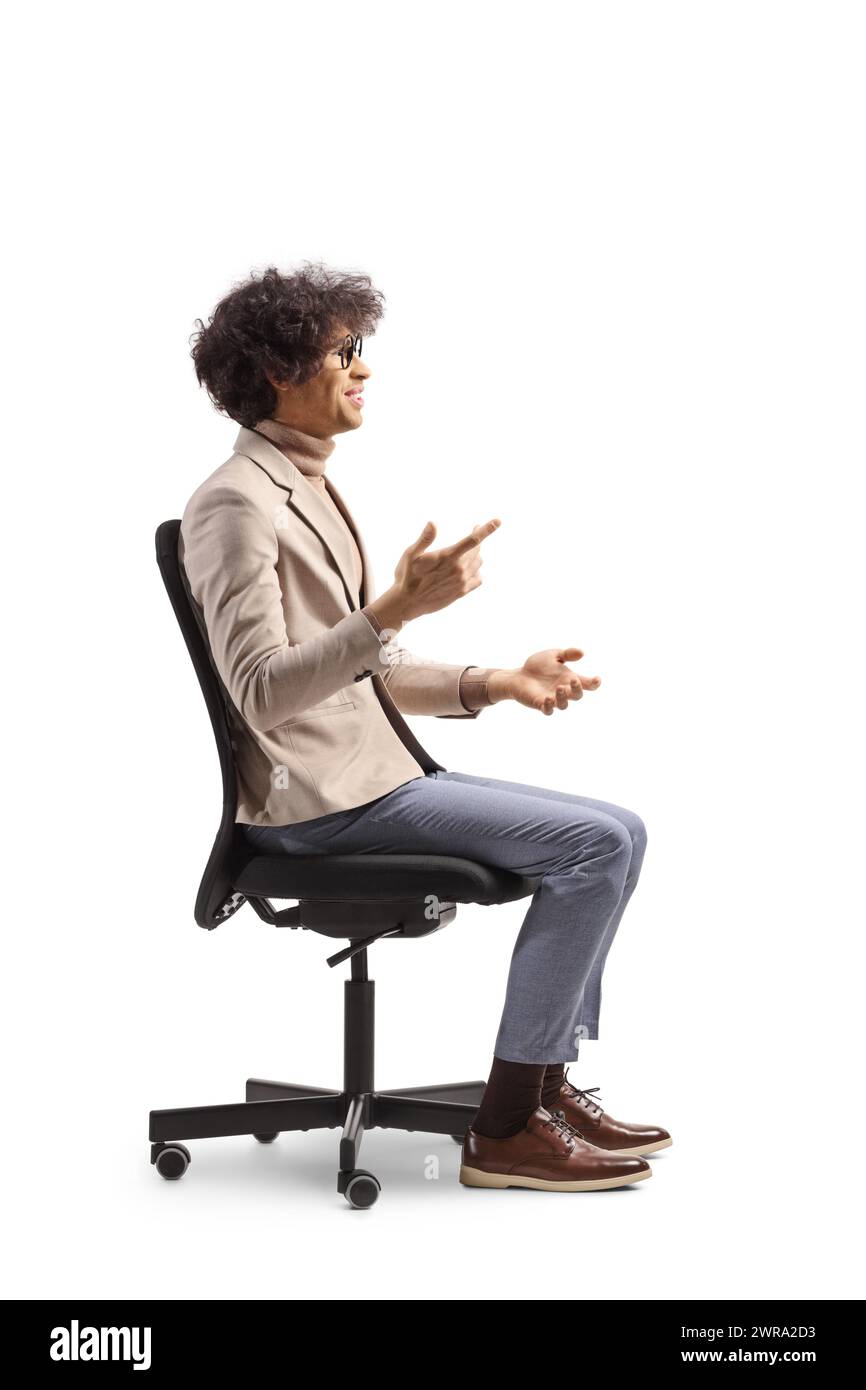 Profile shot of a man sitting in an office chair and explaining with ...
