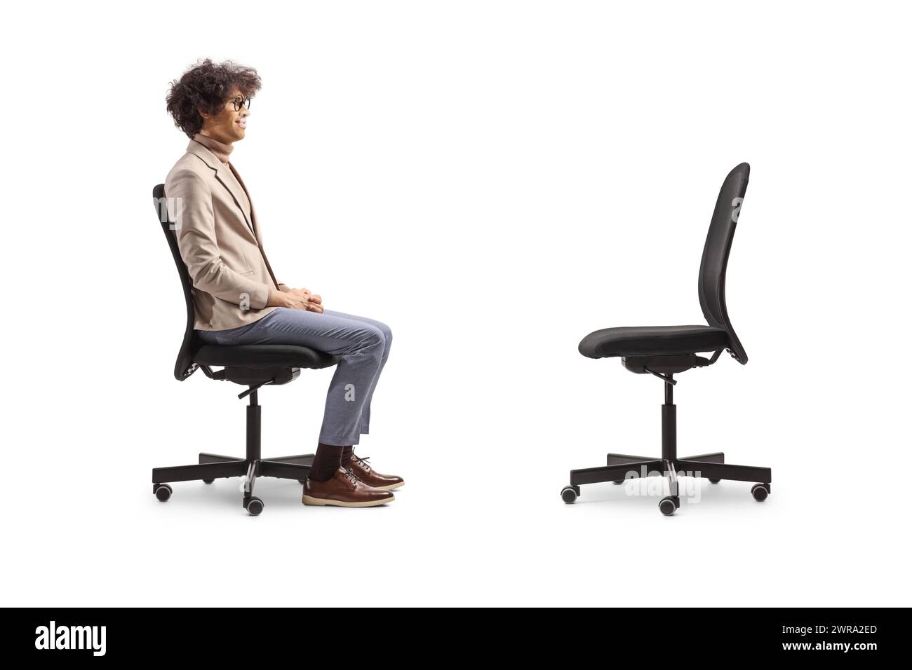 Profile shot of a man sitting in an office chair and looking at an ...