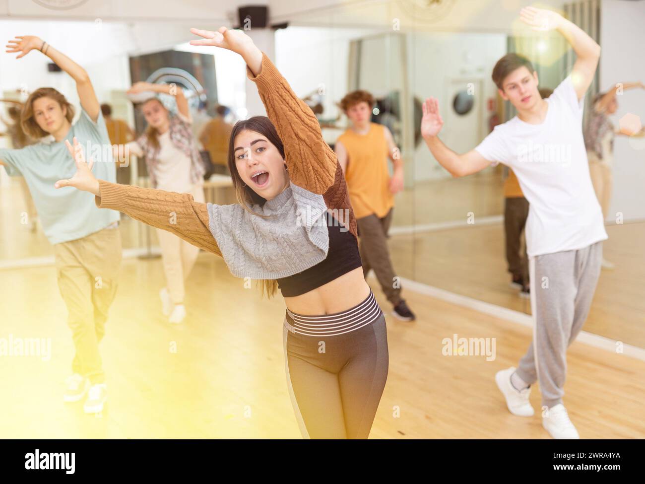 Expressive hispanic teenage girl practicing energetic dance movements ...