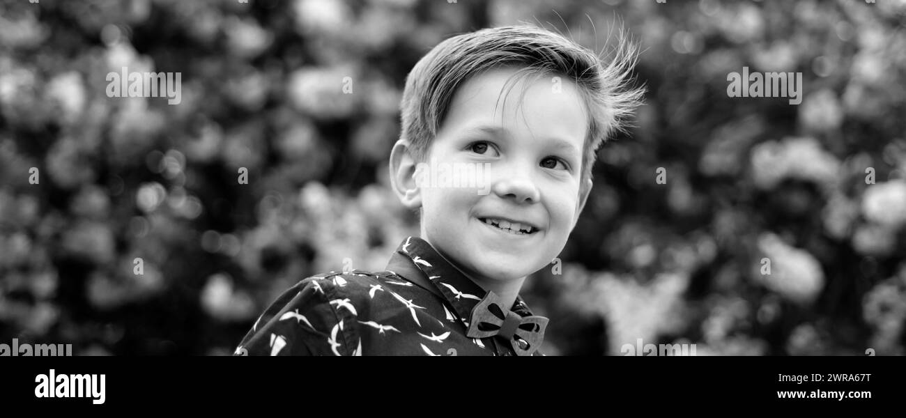 Banner with spring child face. Smiling child happy boy in pink blooming ...
