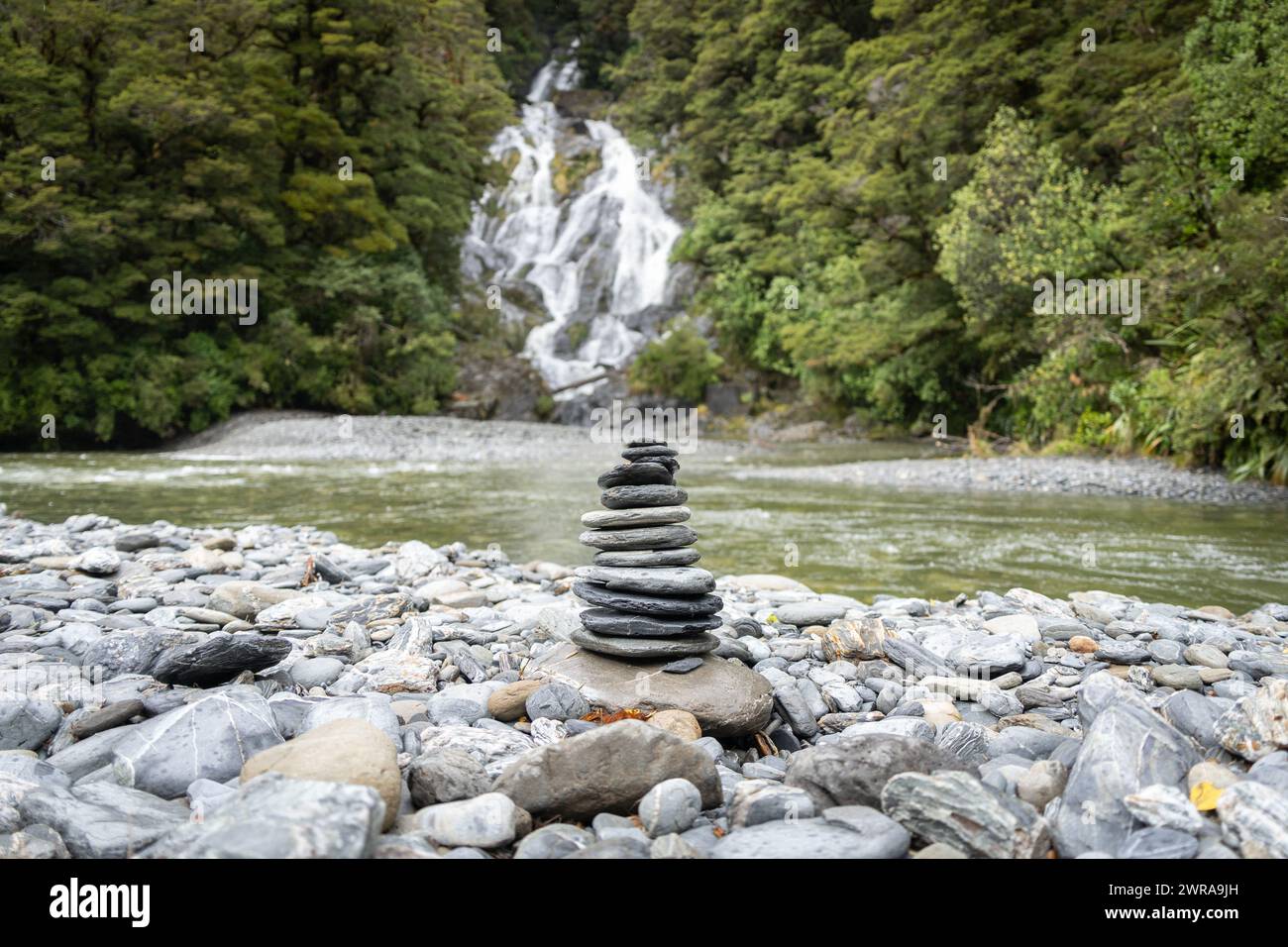 Stack of rocks, cairn, positioned on a pebble beach in front of big ...