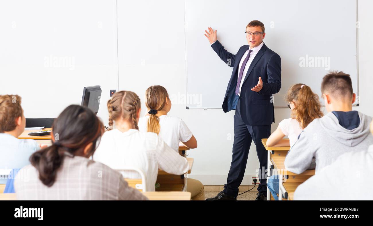 Male teacher lecturing to students at classroom Stock Photo - Alamy