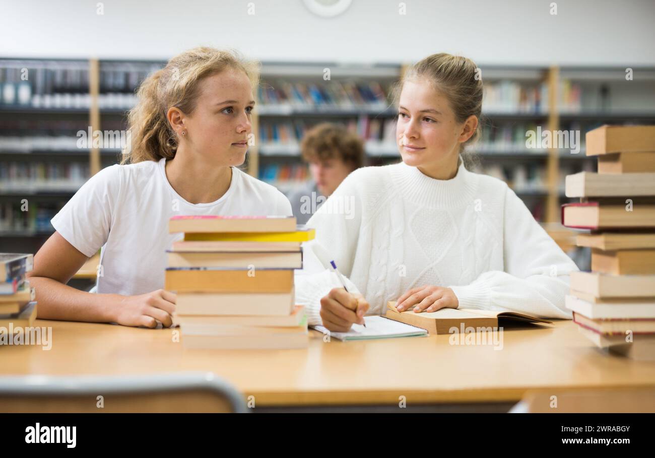 Two friends are studying in school library. Exam preparation Stock ...