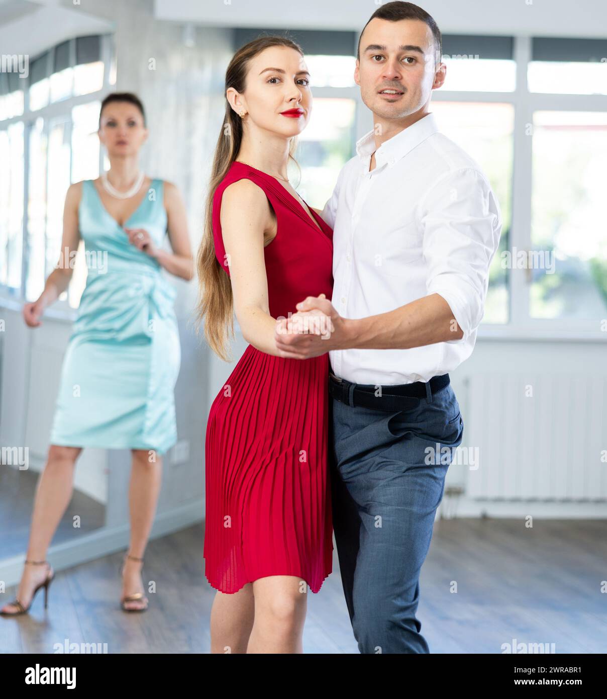 Couple in stage costumes learns tango dancing during individual lesson ...