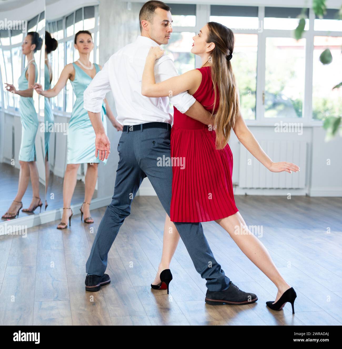 Couple in stage costumes learns tango dancing during individual lesson ...