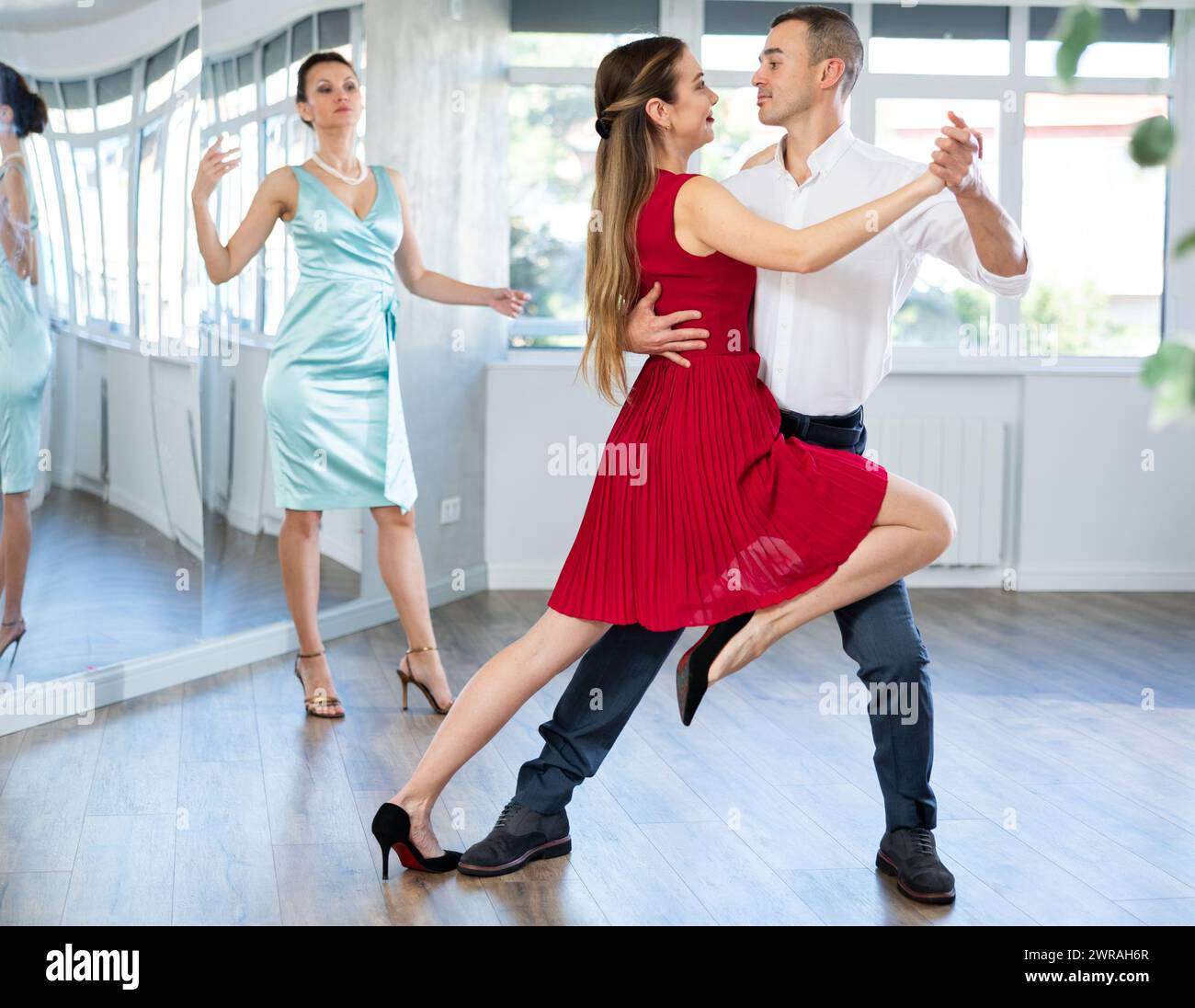 Couple in stage costumes learns tango dancing during individual lesson ...
