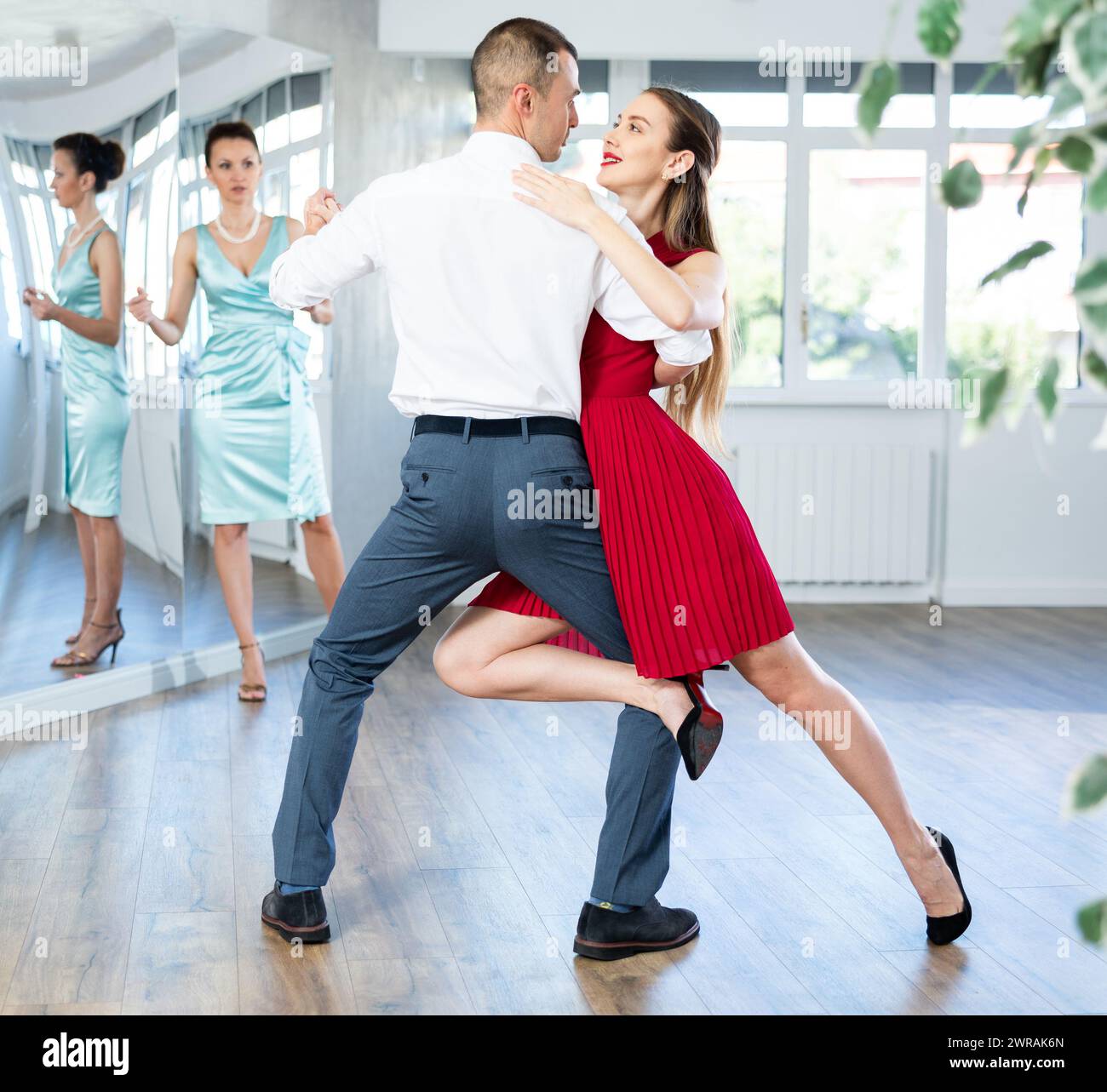 Woman in red and man in formal wear rehearsing tango in pair Stock ...
