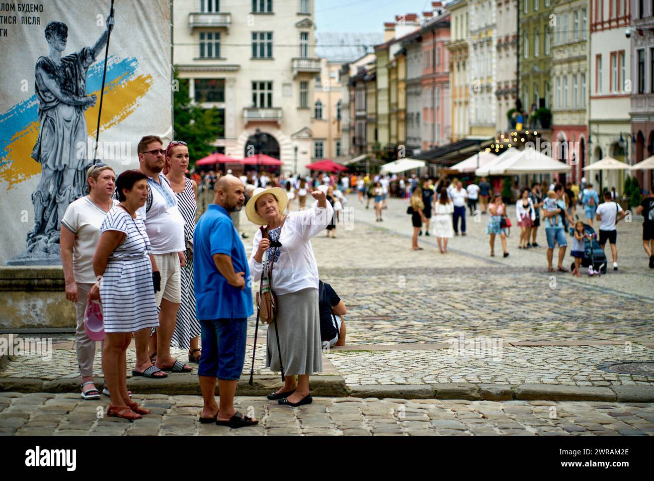 Lviv, Ukraine - JULY 30, 2022: An Ukrainians tourist group at the Rynok Square (Market Square ...